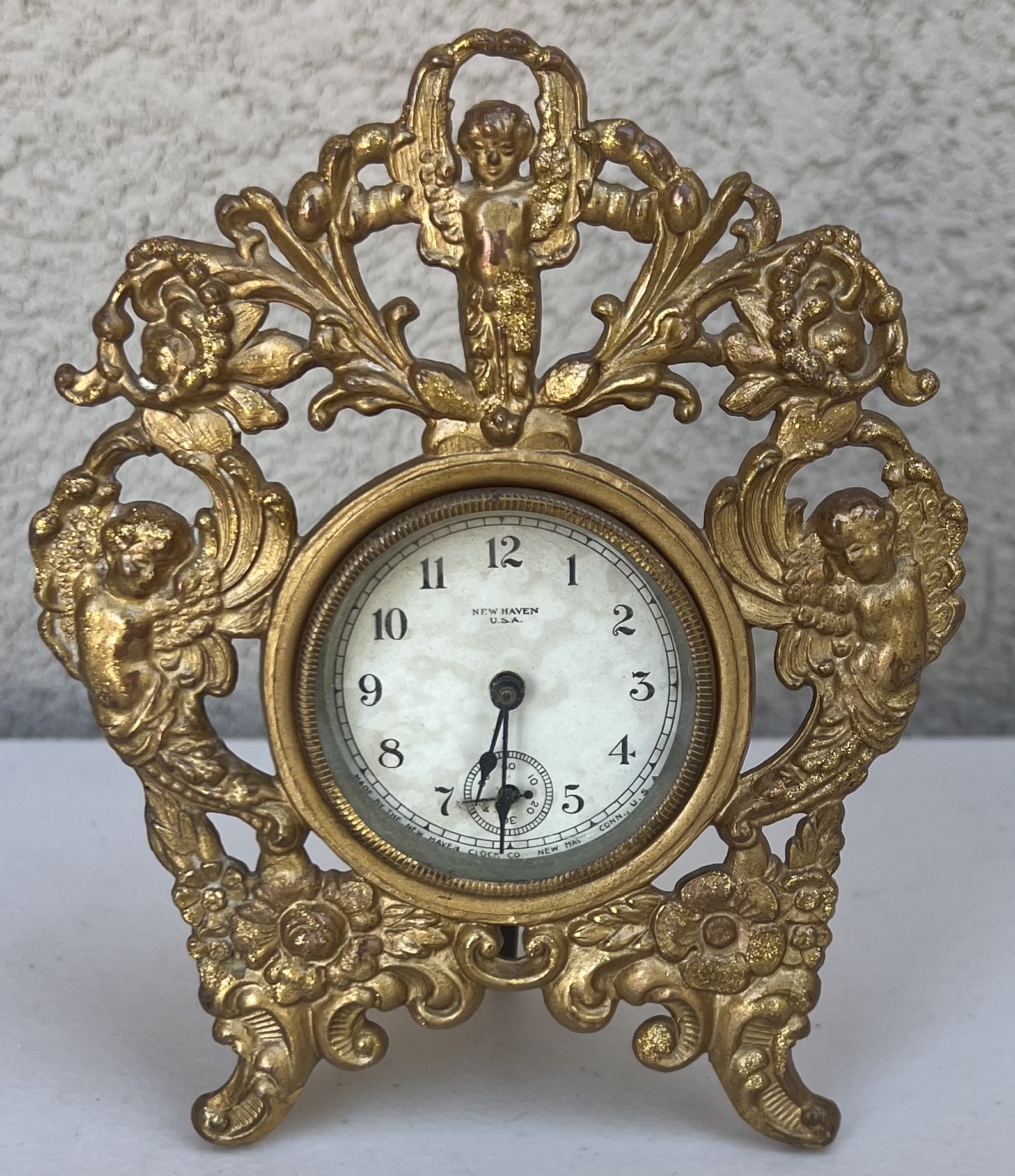Vintage Brass New Haven Cherub Clock With Stand #41596 | Auctionninja.com